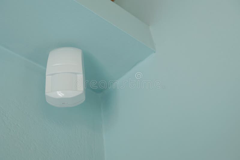 Motion Sensor or Detector for Security System Mounted on Blue Wall in ...