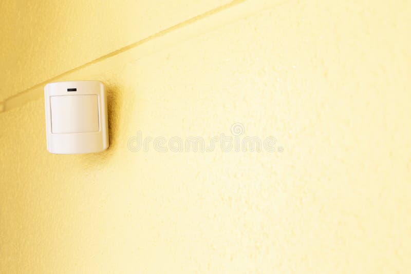 Motion Sensor or Detector for Security System on a Yellow Wall Indoors ...