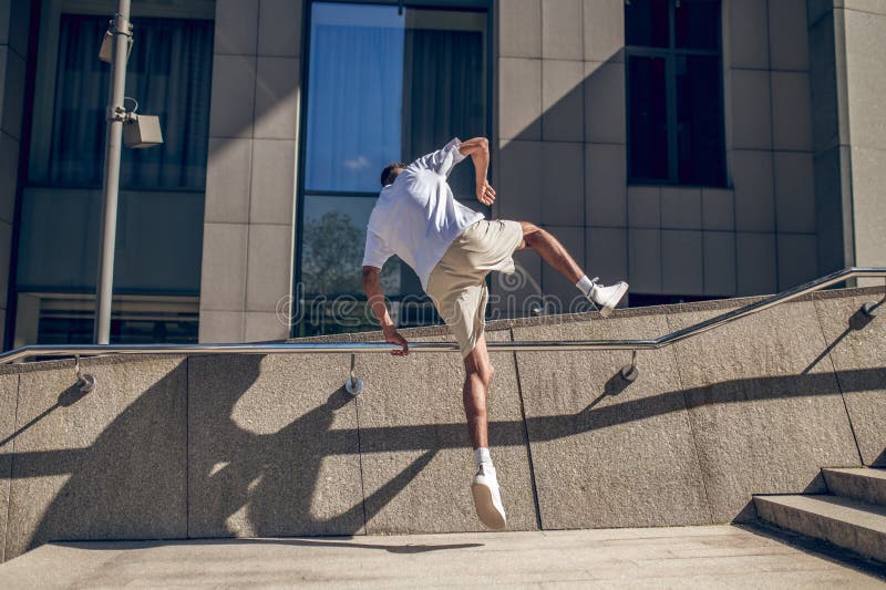 Young Man in White Tshirt Jumping and Looking Energized Stock Photo ...