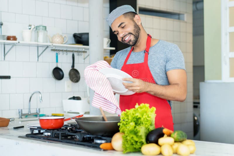 Motivated Hispanic Kitchen Assistant Cleaning Plates at Work Stock ...