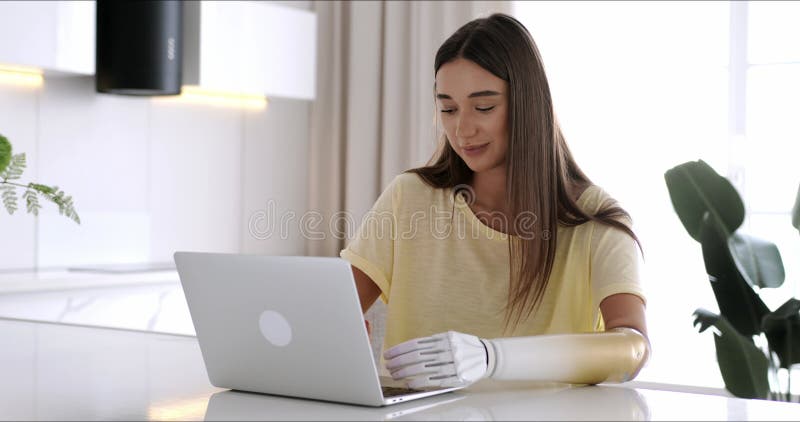 Motivated Woman Using Prosthetic Arm Working or Learning Notebook ...