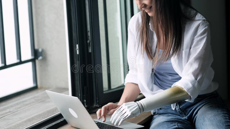 Motivated Woman Using Prosthetic Arm Working or Learning Notebook ...