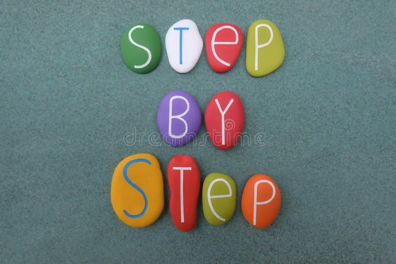 Step by Step Text Composed with Multi Colored Stones Over Green Sand ...