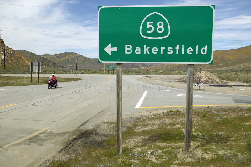 A Motorcycle Driving Past a Road Sign Editorial Photo - Image of signs ...
