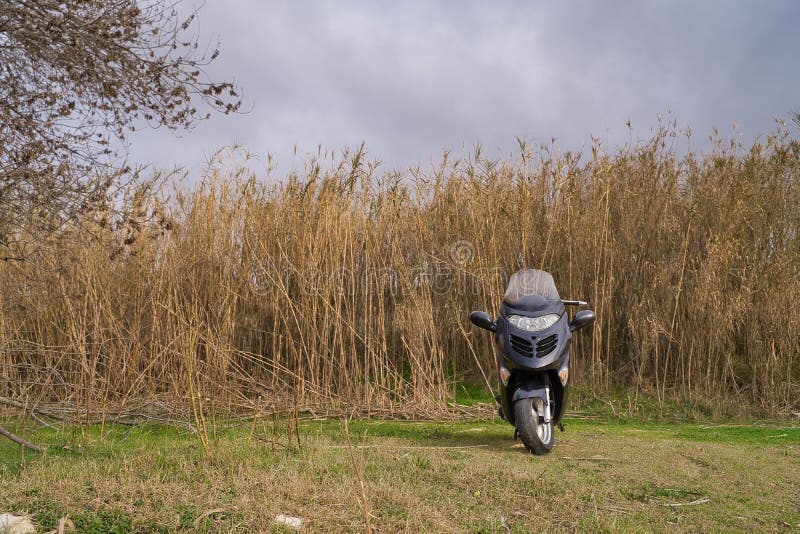 Motorcycle Parked in Front of a Dried Grass Field on a Cloudy Day ...