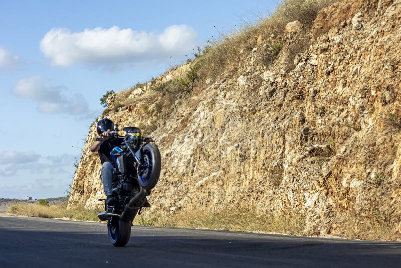 A Motorcycle Racer Performs a Difficult and Dangerous Stunt on His ...