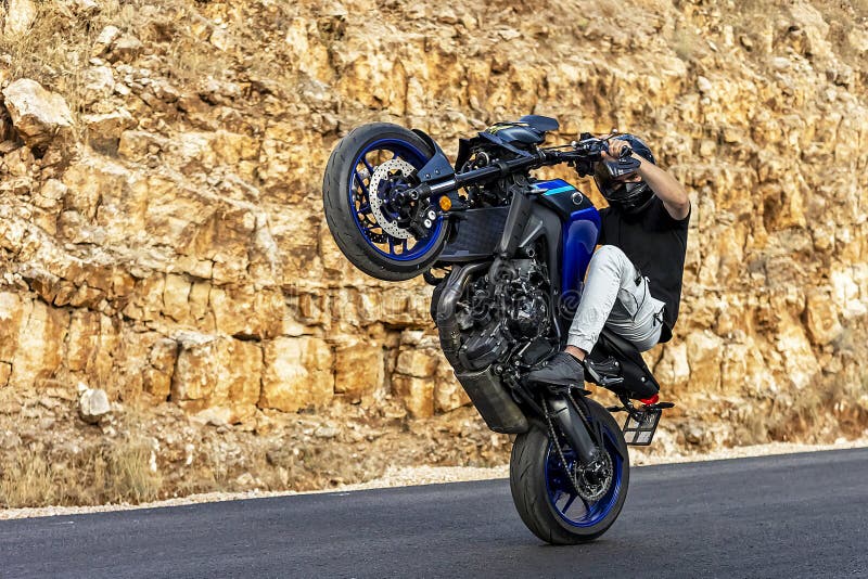A Motorcycle Racer Performs a Difficult and Dangerous Stunt on His ...