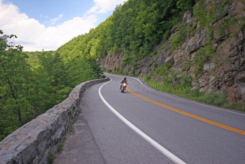 Motorcycle Riding Down Curvy Road. Stock Image - Image of rock, plants ...