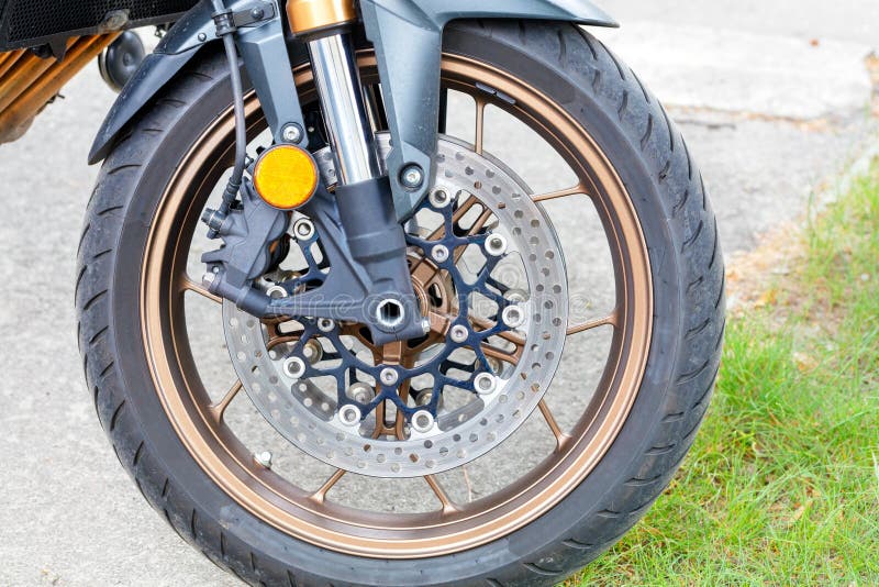 Motorcycle Wheel on a Background of Asphalt and Green Grass in Blur ...