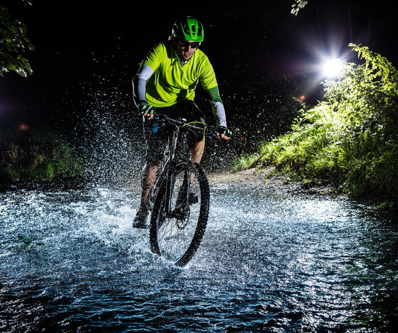 Mountain Biker Speeding through Forest Stream. Water Splash in Freeze ...