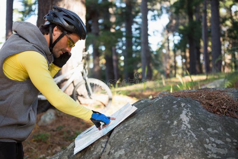 Mountain Biker Talking Mobile Phone while Looking at Map Stock Photo ...