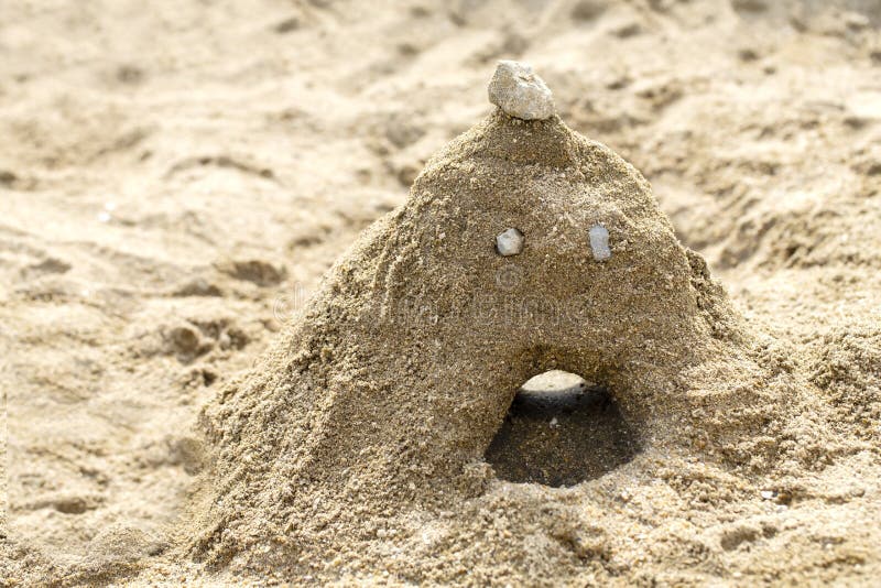 A Mountain Made of the Sand with the Face Made by Kids in Sandbox on a ...