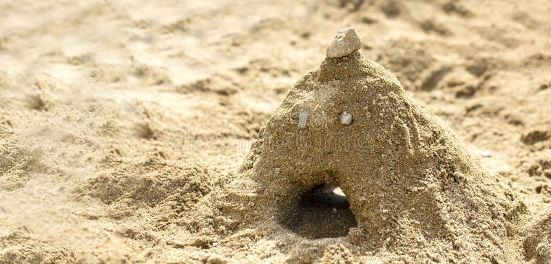 A Mountain Made of the Sand with the Face Made by Kids in Sandbox on a ...