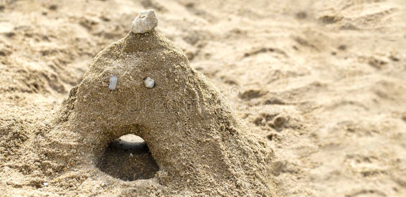 A Mountain Made of the Sand with the Face Made by Kids in Sandbox on a ...