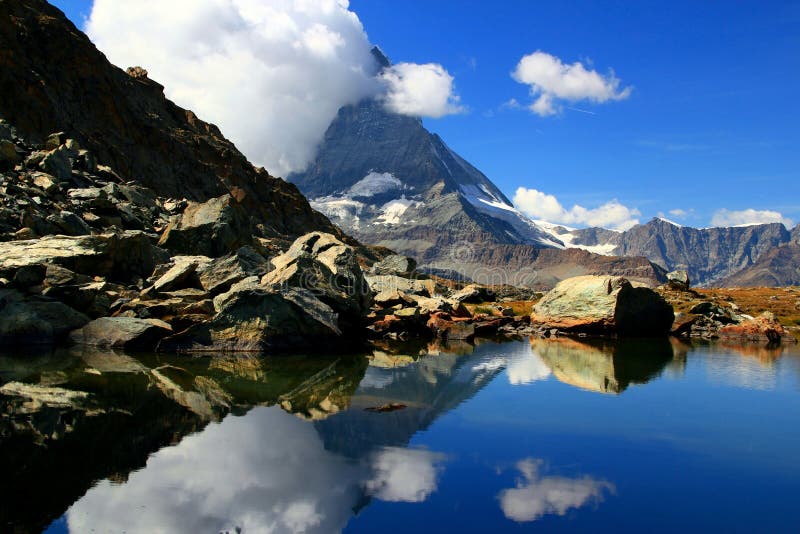 A Mountain Matterhorn View Partially Covered by Clouds and Reflected in ...