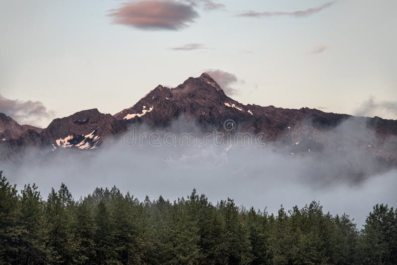 Mountain Peak and Cloudy Forest at Sunset Time in Alaska National Park ...