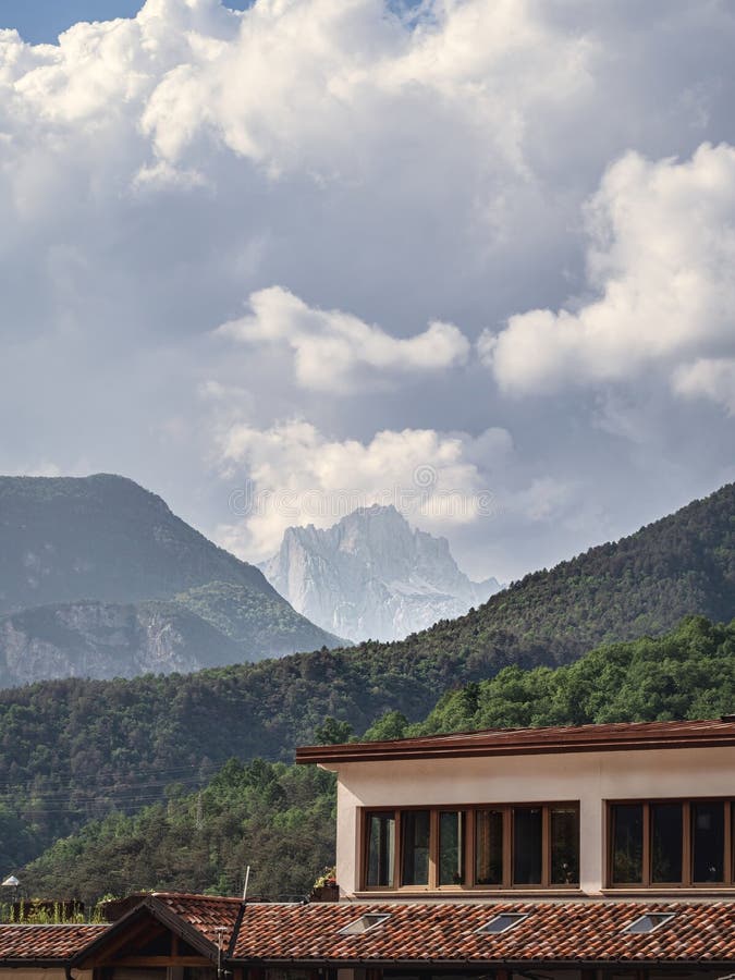 Mountain Peak Emerging from Clouds Above Modern House Stock Photo ...
