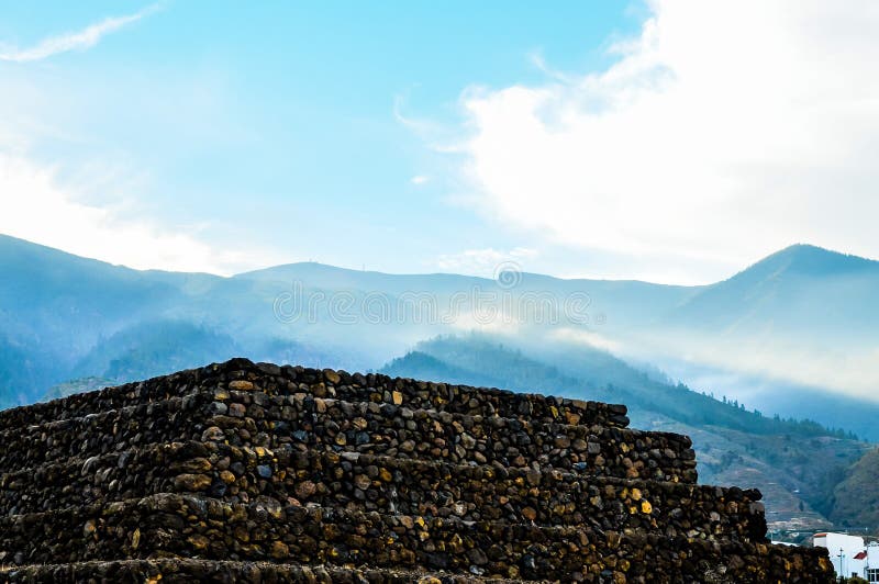 A Mountain Range with a Large Stone Structure in the Middle Stock Image ...