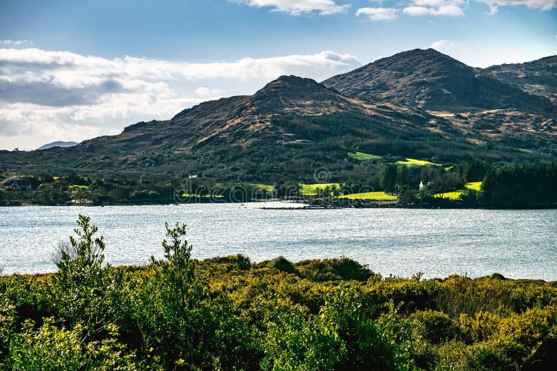 A Mountain Range with a Valley and a Body of Water in the Foreground ...
