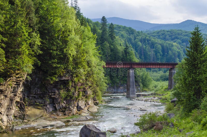 Mountain River with a Rapid Current of Rocks and a Bridge Stock Image ...