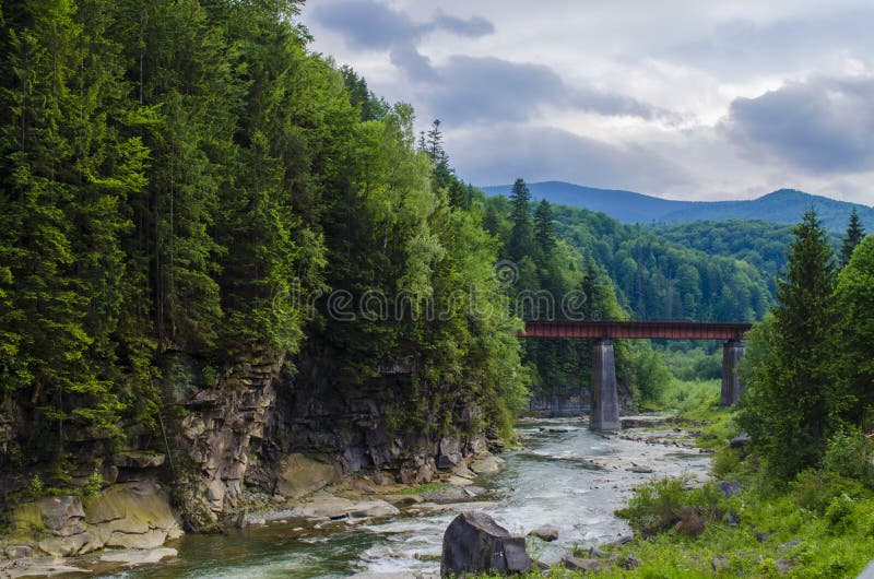 Mountain River with a Rapid Current of Rocks and a Bridge Stock Photo ...