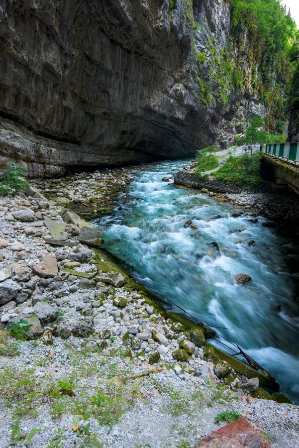Mountain River between Sheer Cliffs . Blue Clear Water of the River ...