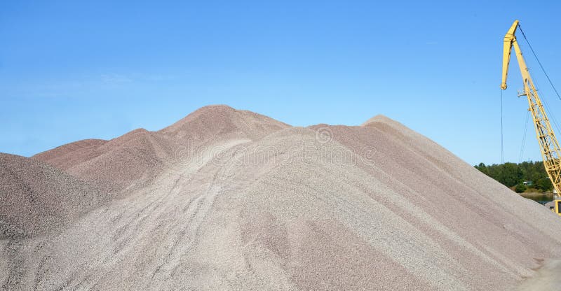 A Mountain of Rubble and a Crane on a River Pier. Summer Day Stock ...