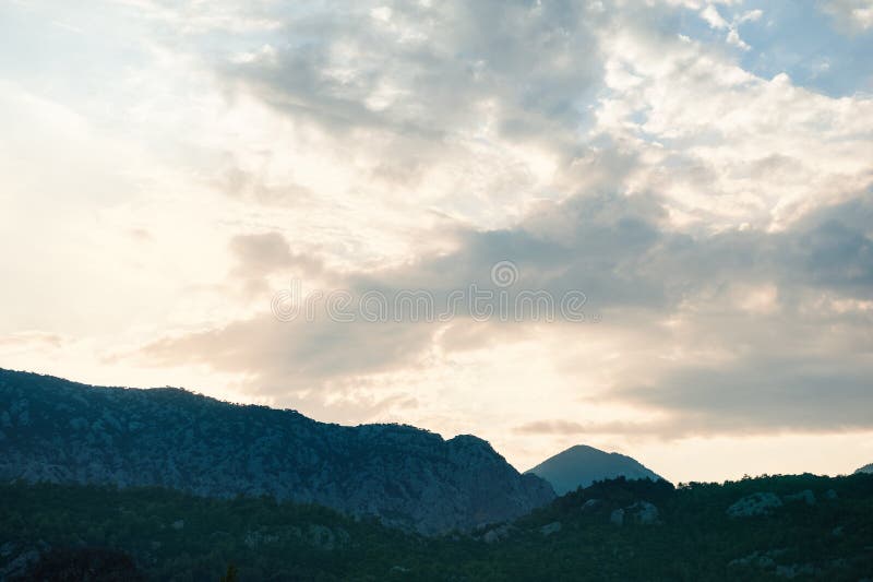 Mountain Silhouettes Under Dramatic Sunset Clouds. Serene Dusk ...