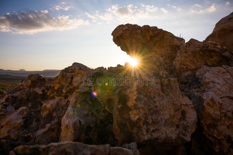 Sunset in Mountains with Sun Hiding Behind Rock Stock Photo - Image of ...