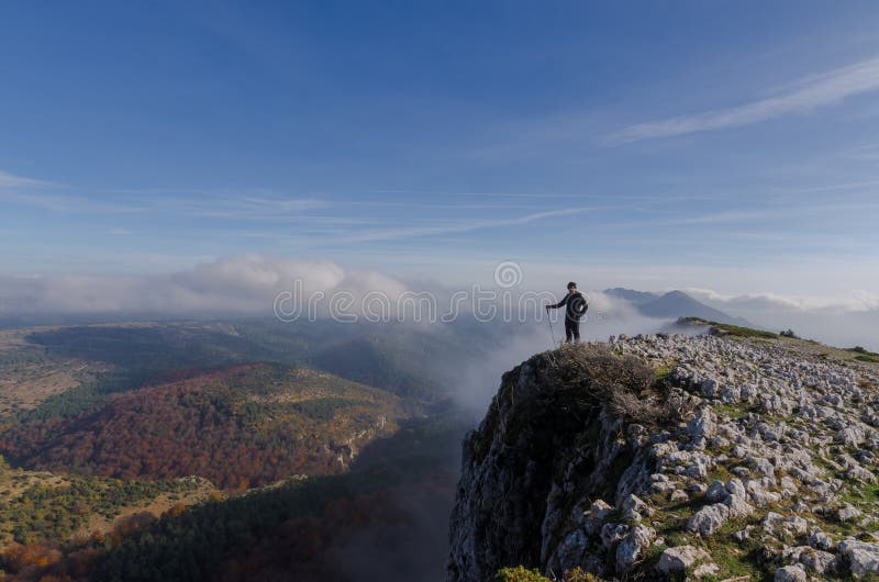 Mountaineer on the Summit with Autumn Forest and Clouds Stock Photo ...