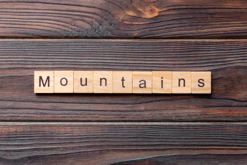 Mountains Word Written on Wood Block. Mountains Text on Cement Table ...
