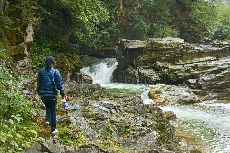 Young Woman Walking Along the Wild Rocky Bank of a Mountain River Stock ...