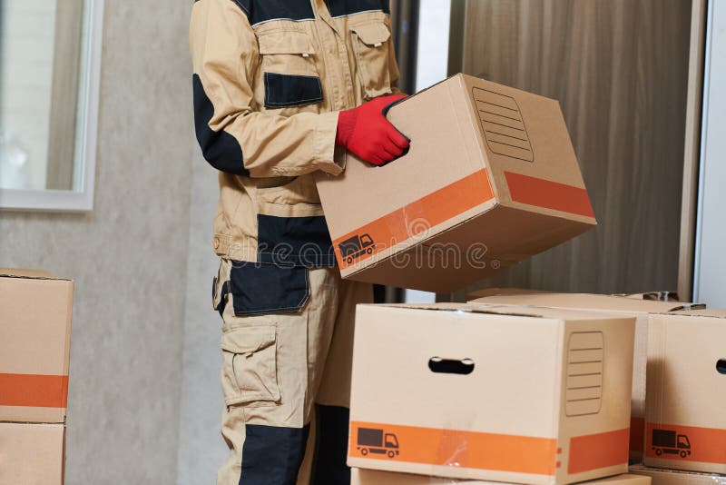 Moving or Delivery Service. Mover Worker Carrying Cardboard Boxes into ...