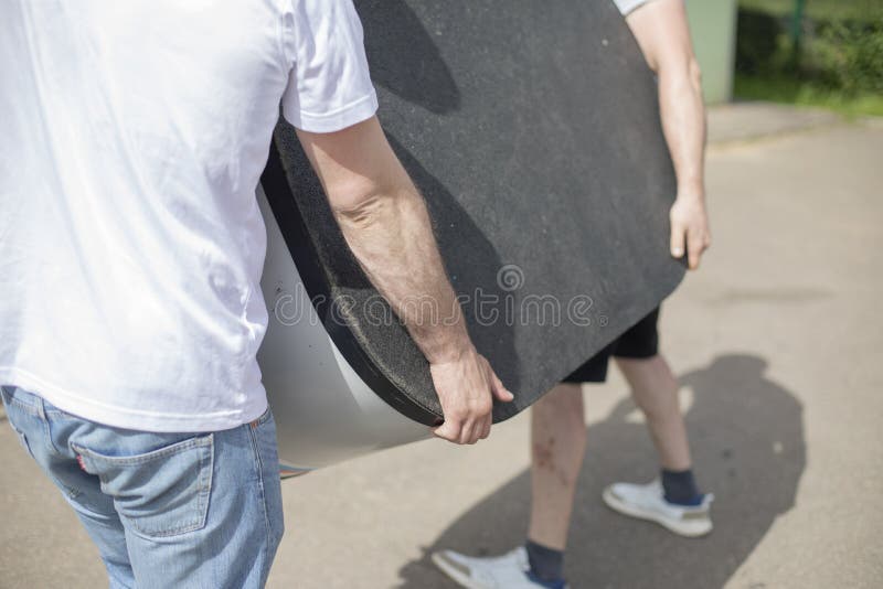 The Movers are Dragging the Table. Men Carry the Burden Stock Photo ...