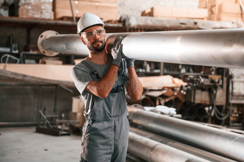 Moving Big Metal Pipe. Young Factory Worker in Grey Uniform Stock Photo ...