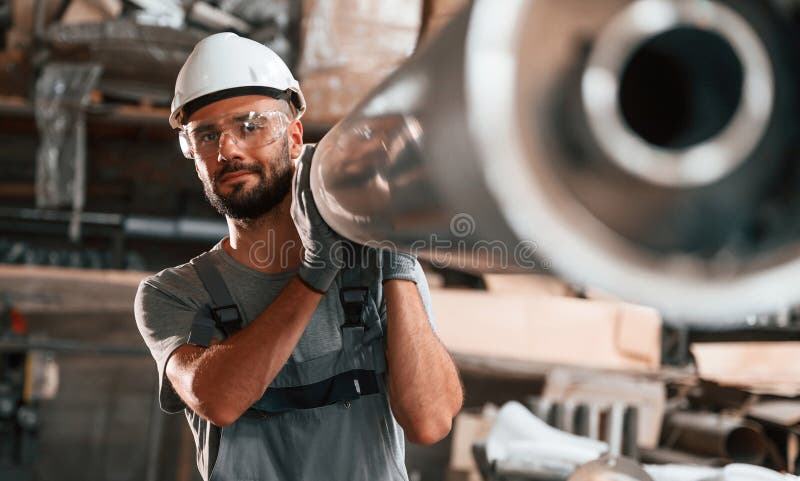 Moving Big Metal Pipe. Young Factory Worker in Grey Uniform Stock Photo ...
