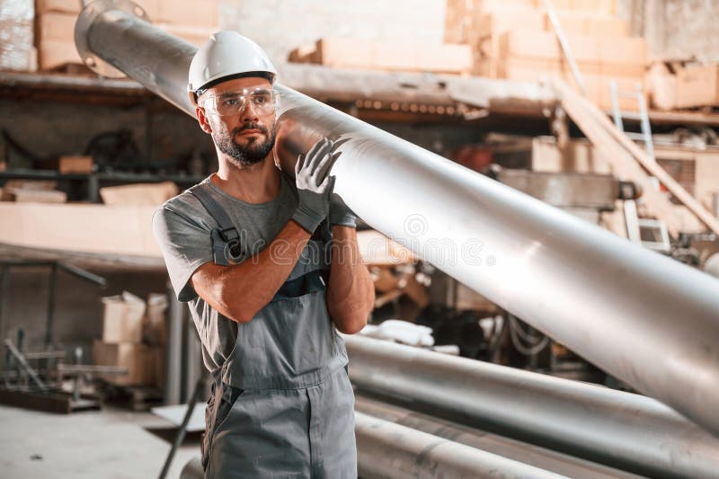 Moving Big Metal Pipe. Young Factory Worker in Grey Uniform Stock Photo ...