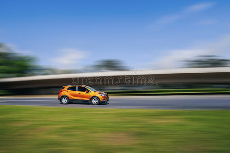A Moving Car. Orange SUV Driving Down the Street Stock Photo - Image of ...