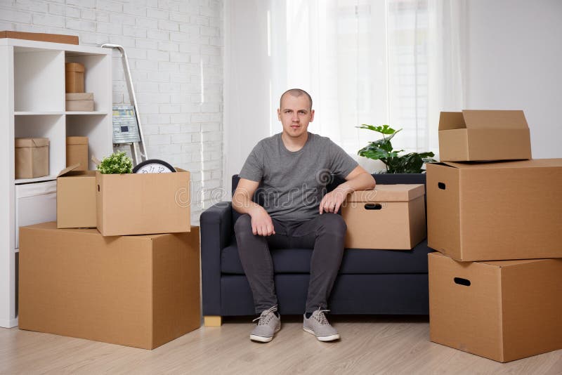 Moving Day Concept - Happy Man Sitting on Sofa in Room Stock Image ...