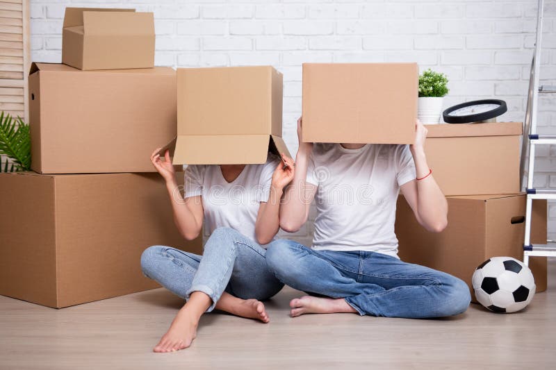 Moving Day - Young Couple Embracing in Their New House Surrounded ...
