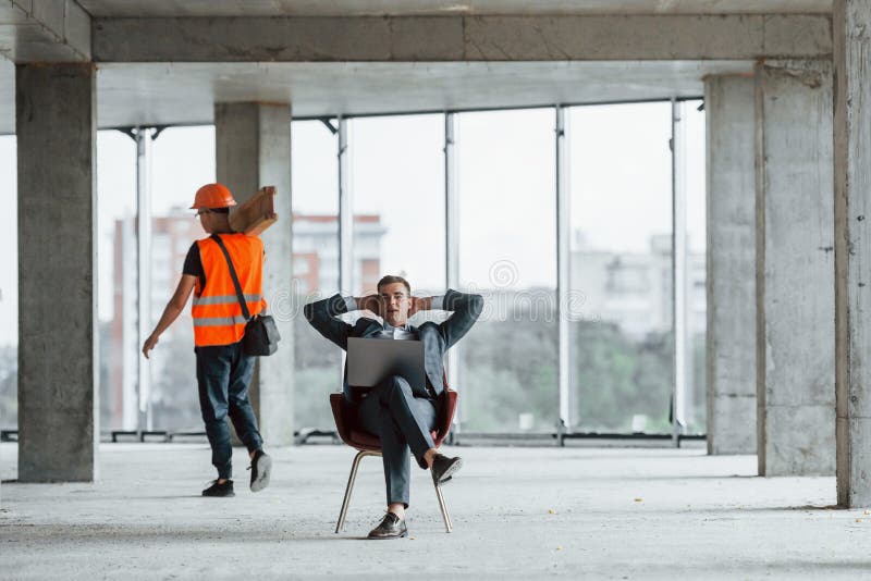 Moving Object. Man in Suit and Handyman in Orange Protective Wear is ...