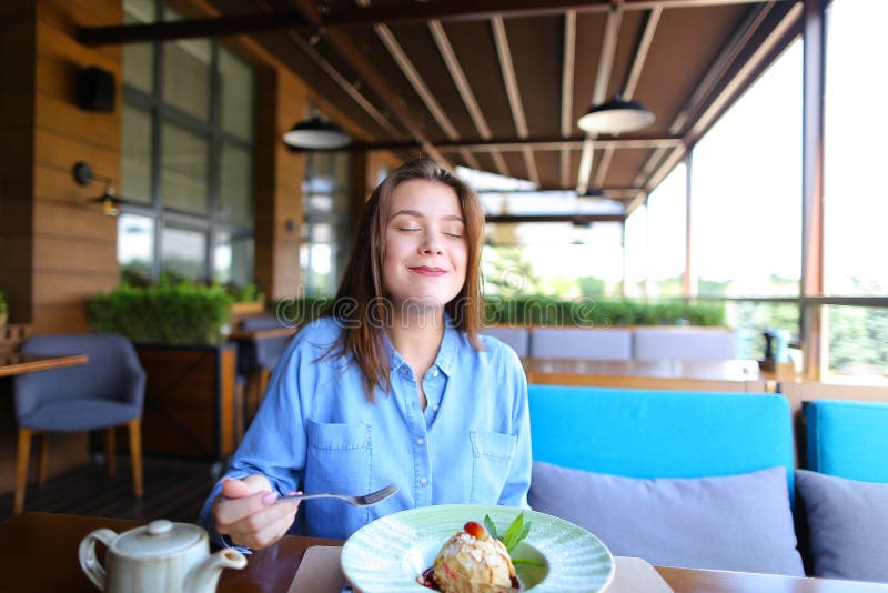 Chica Satisfecha Comiendo Postre En Un Restaurante Imagen de archivo ...