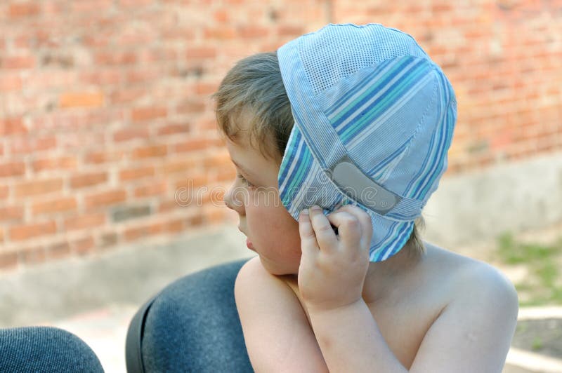 Muchacho Devuelto, Poniendo Un Casquillo Foto de archivo - Imagen de ...