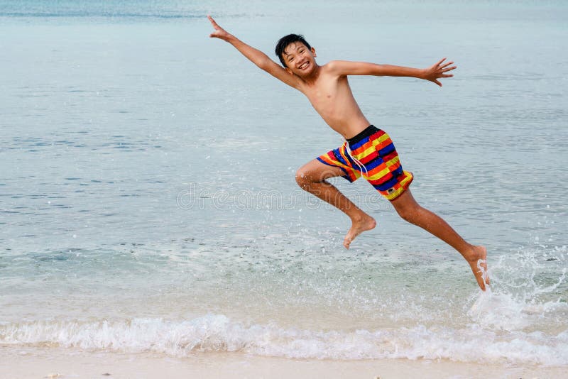 Muchacho Joven Que Salta En La Playa Foto de archivo - Imagen de ...