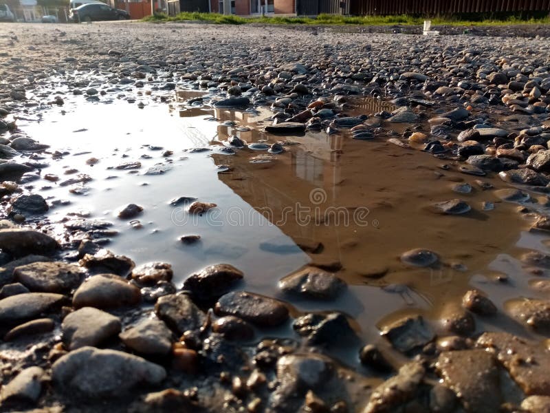 Mud Puddle with Silt on Stones Stock Photo - Image of silt, water ...