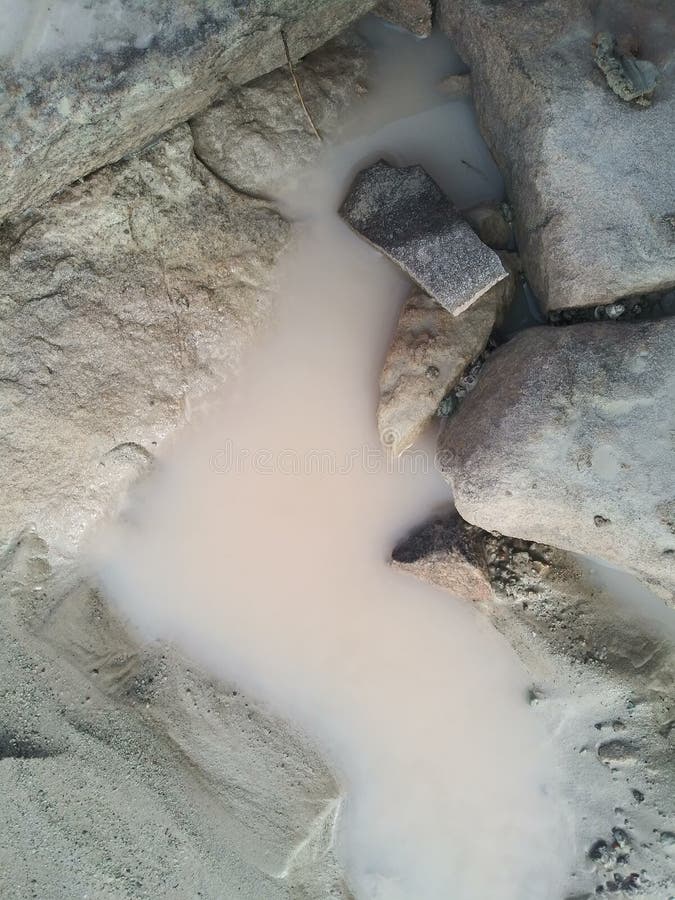 Muddy puddle with rocks stock photo. Image of water - 142820104
