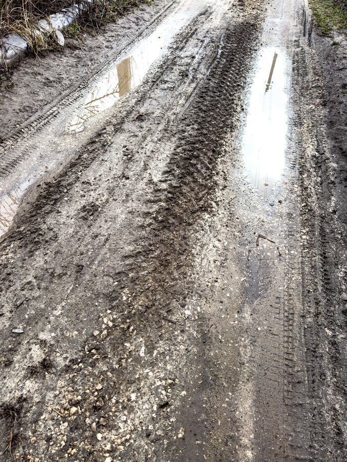 A Muddy Road with a Reflection of a Pole in the Water Stock Image ...