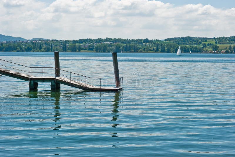 Muelle que lleva al lago foto de archivo. Imagen de nubes - 14616448