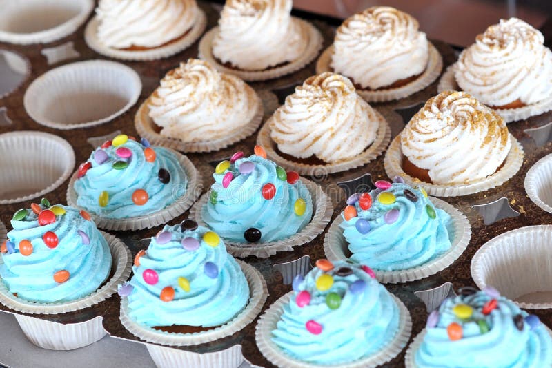 Multiple Muffins Decorated with Multicolored Frosting, Cocoa Powder and ...