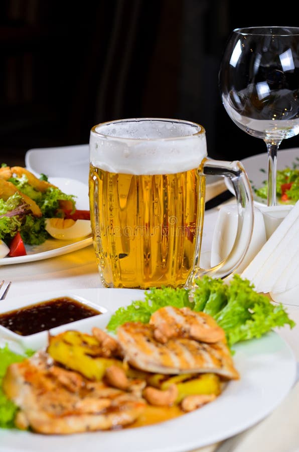 Mug of Beer Amidst Plated Dishes on Table Stock Image - Image of meal ...